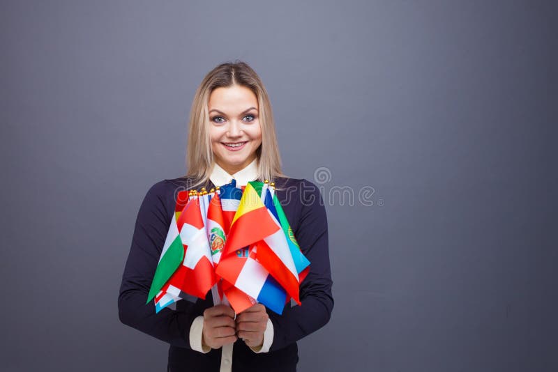 Cheerful Young Woman with a Large Set of Flags of Different Countries ...