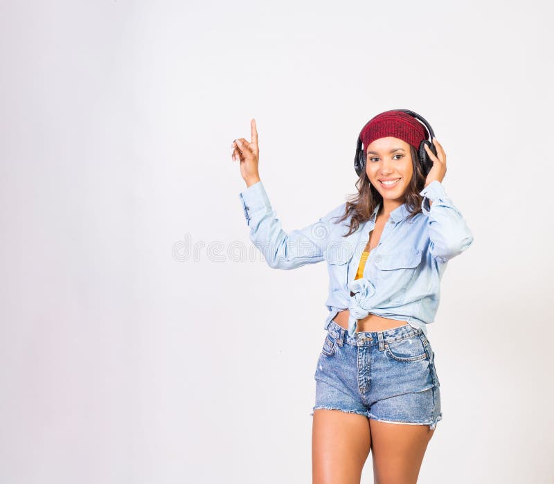 Cheerful Young Woman with a Positive Expression Points Up on a White ...