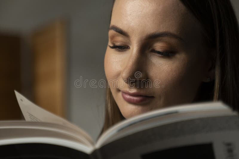 A Cheerful Young Woman, Reading a Book, Studying Alone, Sitting on the ...