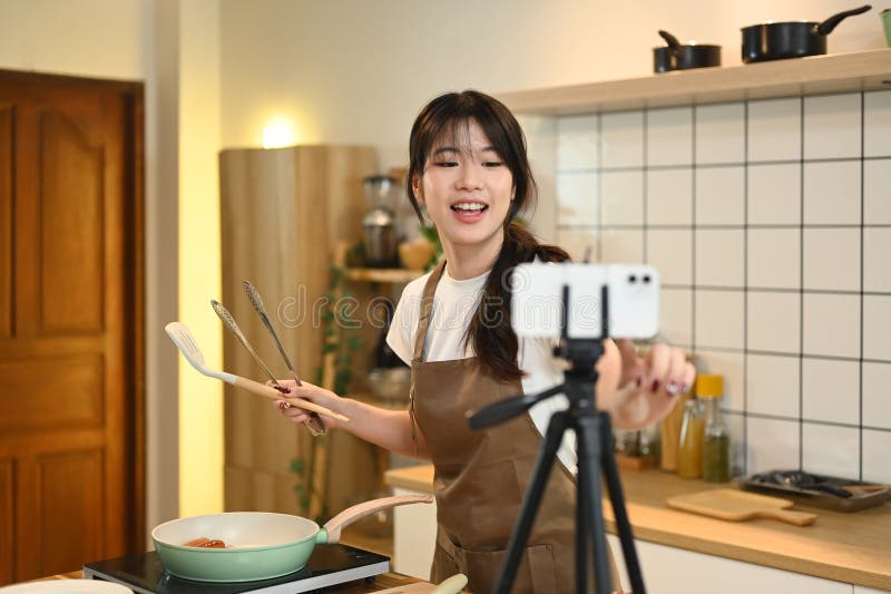 Cheerful Young Woman Recording a Cooking Tutorial in a Modern Kitchen ...