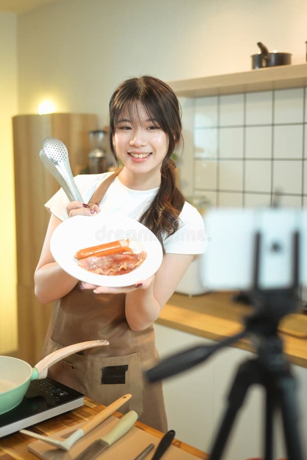 Cheerful Young Woman Recording a Cooking Tutorial in a Modern Kitchen ...
