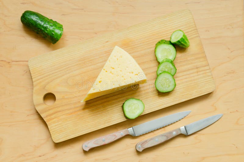 Cheese and Chopped Cucumber are on a Kitchen Board Stock Photo - Image ...