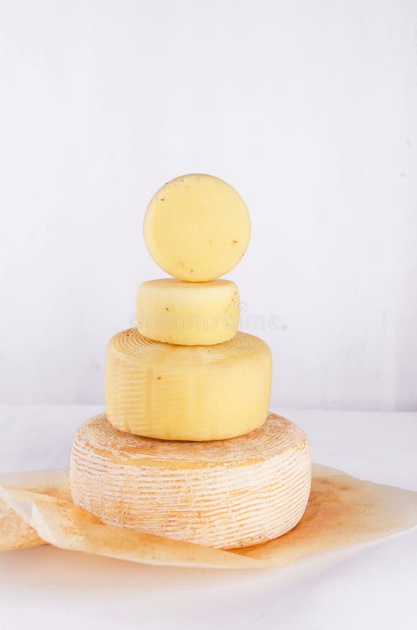 Cheese Heads of Different Kinds Stacked on Table Stock Image - Image of ...
