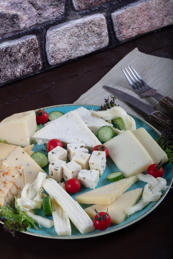 Cheese Plate on a Dark Table. Many Kinds of Cheese on a Plate Stock ...
