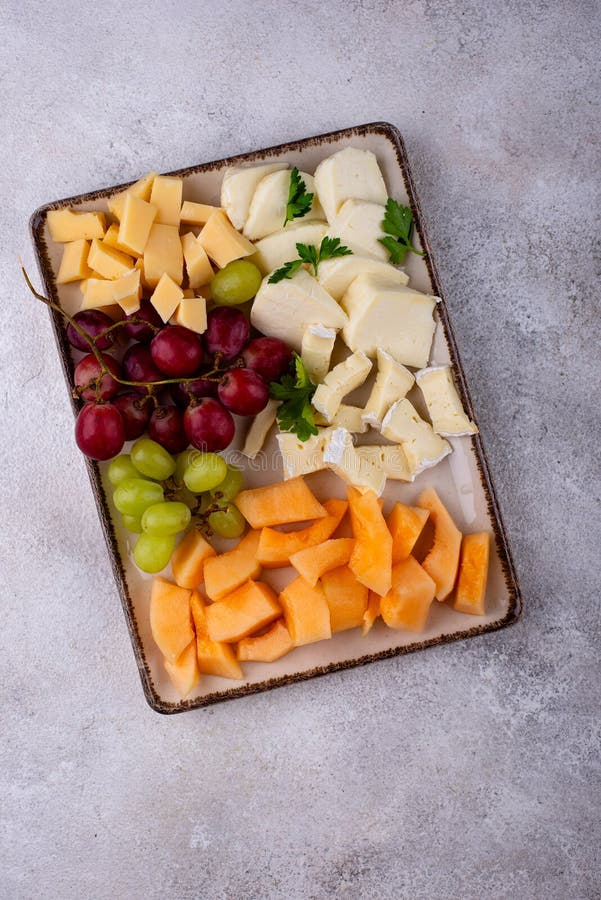 Cheese Plate with Different Cheese, Grapes and Melon. Stock Photo ...