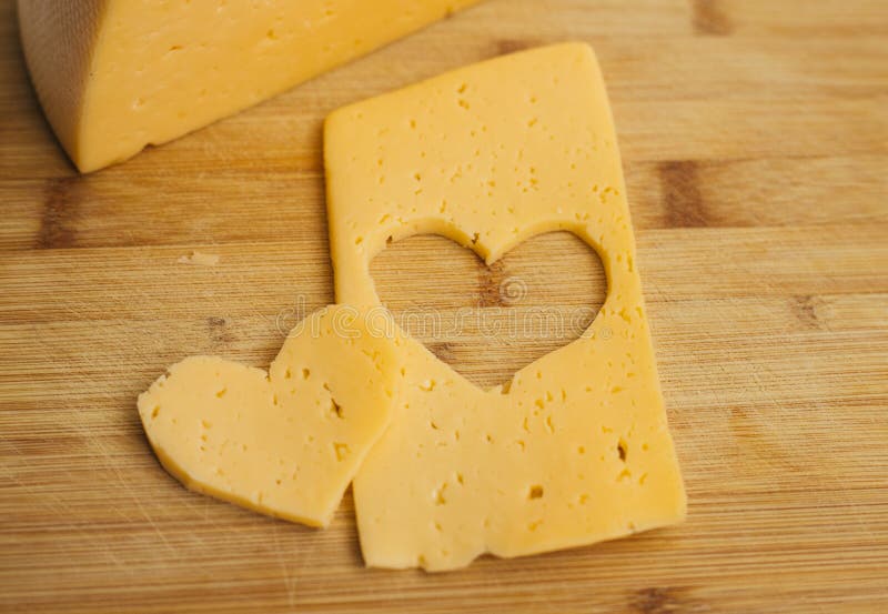 Cheese in the Shape of a Heart on a Wooden Board. Grated Cheese in the ...