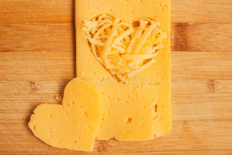 Cheese in the Shape of a Heart on a Wooden Board. Grated Cheese in the ...