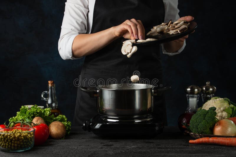The Chef Adding Chopped Mushrooms in Pot with Boiling Water on Dark ...