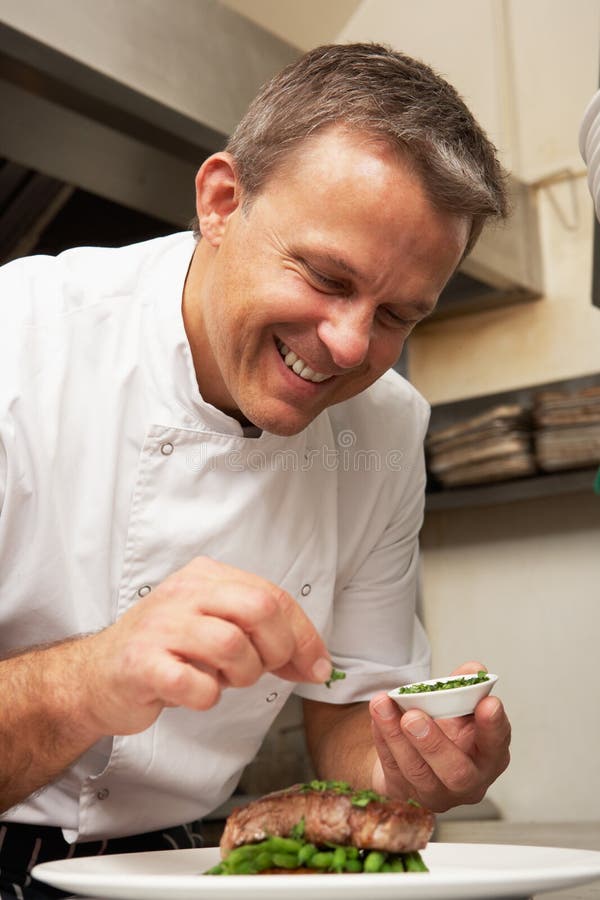 Chef Adding Seasoning To Dish in Kitchen Stock Image - Image of ...