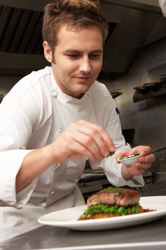 Chef Adding Seasoning To Dish in Restaurant Stock Photo - Image of ...