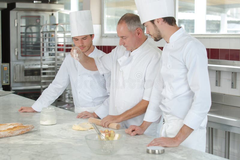 Chef and Apprentices Working at Kitchen Stock Photo - Image of kitchen ...