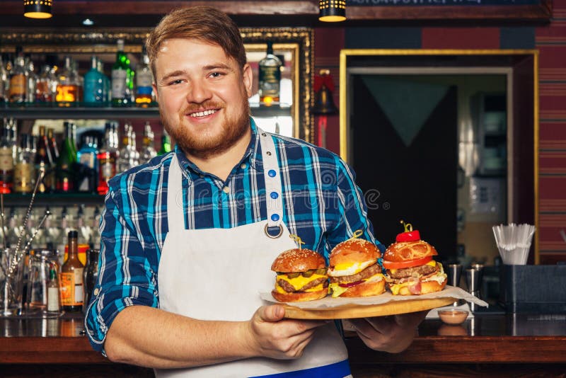 Chef in Apron Presenting a Tray with Different Delicious Burgers Stock ...