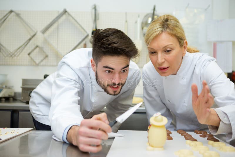 Chef and Assistant Prepare Delicious Chocolates Eggs in Kitchen Stock ...