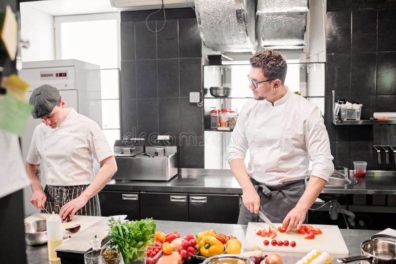 Chef with Assistant Preparing Food in Kitchen Stock Image - Image of ...