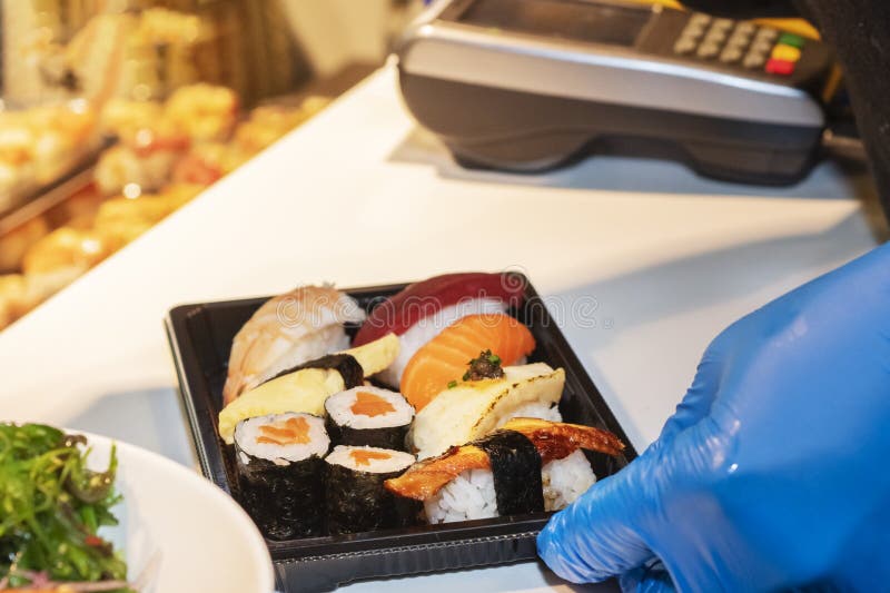 A Chef with Blue Plastic Gloved Hands Assembling a Plate of Sushi for ...