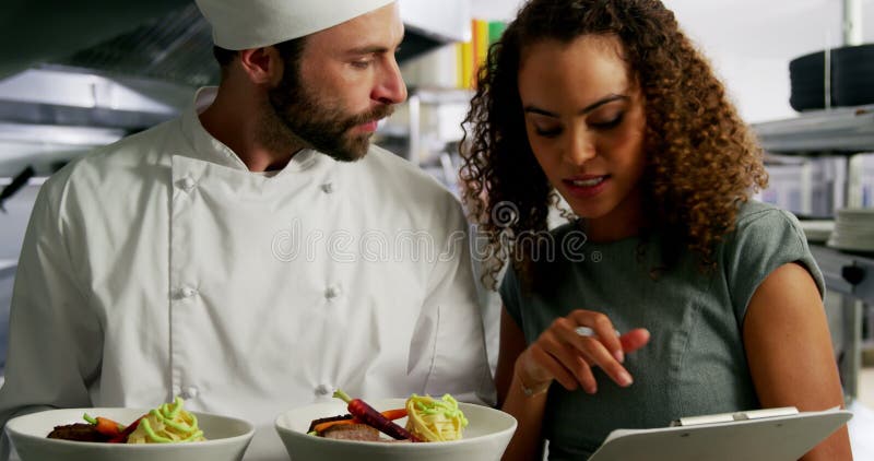 Chef Carrying Food Plates Interacting with Restaurant Manager Stock ...