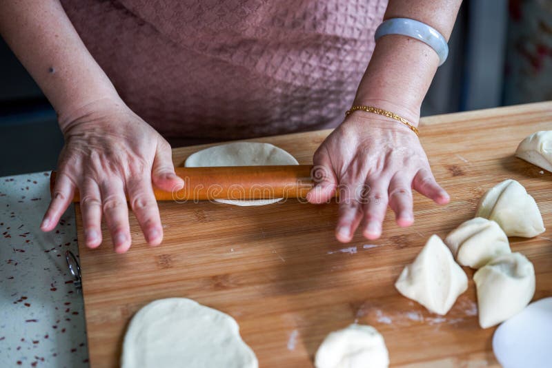 A Chef in a Chinese Kitchen is Making Bun Skins with a Rolling Pin ...