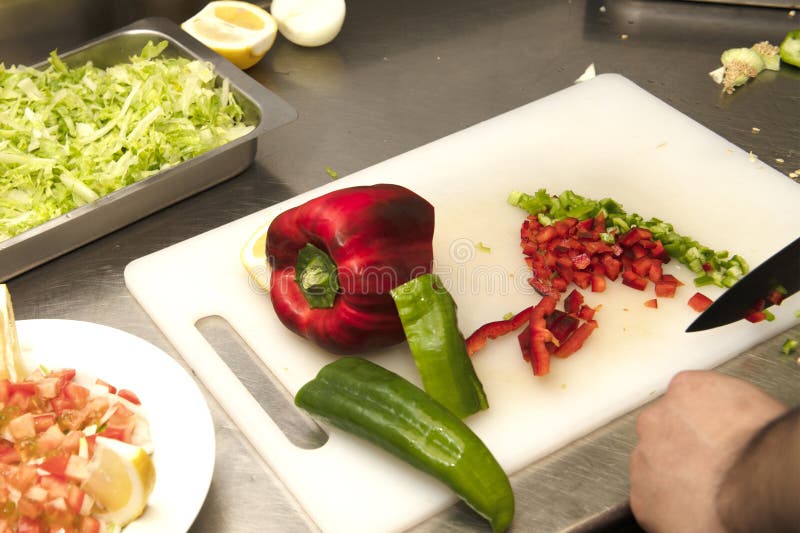 A Chef Chopping Red and Green Bell Peppers on a White Teflon Board ...