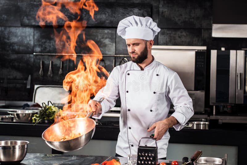 Chef Cook Food with Fire at Kitchen Restaurant. Cook with Wok at ... Chef Cook Food with Fire at Kitchen Restaurant. Cook with Wok at ...