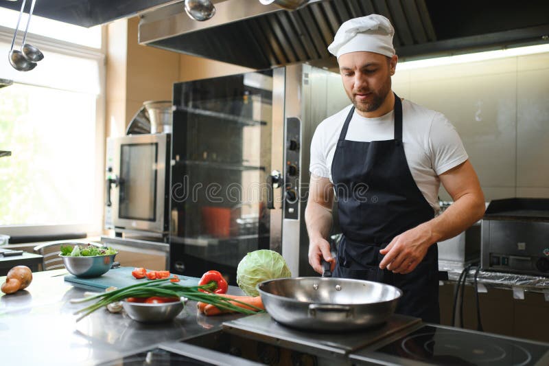 Chef Cook in Uniform Cooking in the Big Cooker at the Restaurant ...