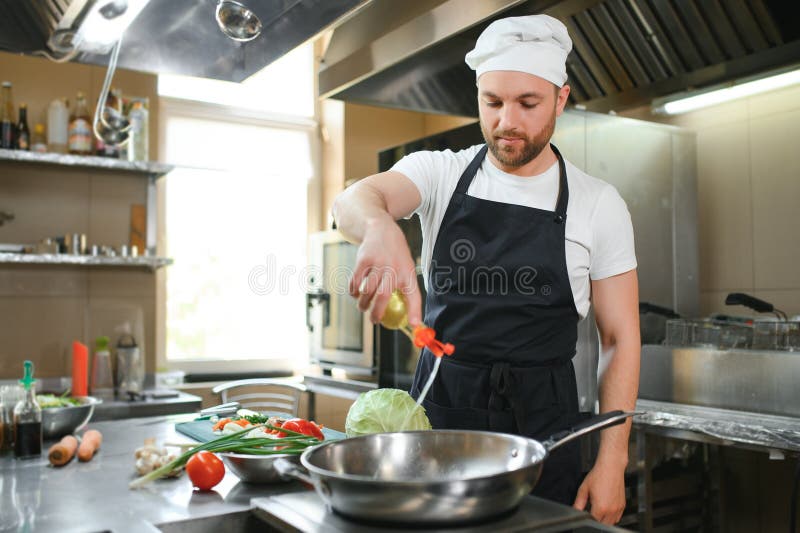 Chef Cook in Uniform Cooking in the Big Cooker at the Restaurant ...