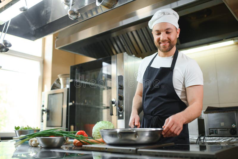 Chef Cook in Uniform Cooking in the Big Cooker at the Restaurant ...