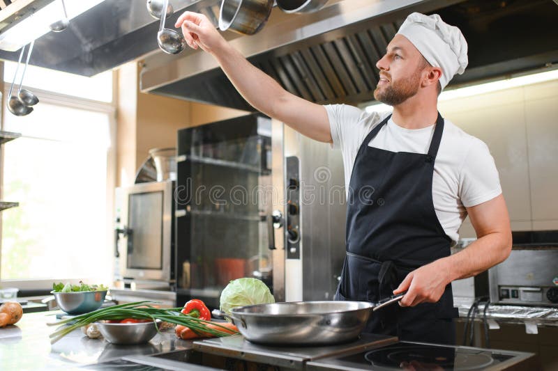 Chef Cook in Uniform Cooking in the Big Cooker at the Restaurant ...