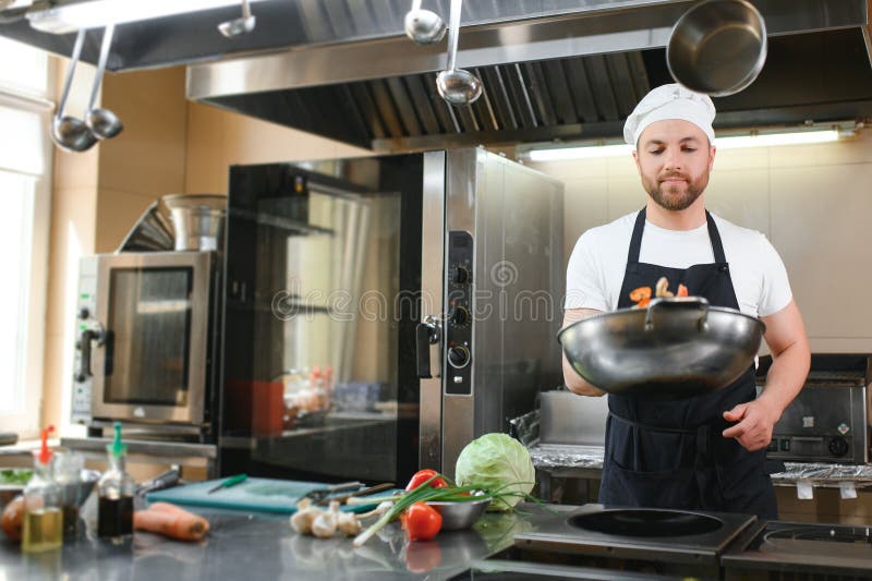 Chef Cook in Uniform Cooking in the Big Cooker at the Restaurant ...