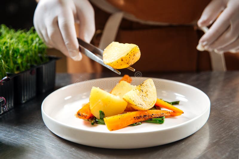 Chef is Cooking Potatoes, Healthy Salad on a White Plate Stock Image ...