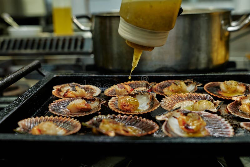 Chef Cooking Scallops on the Griddle and Adding Sauce, No Faces Shown ...