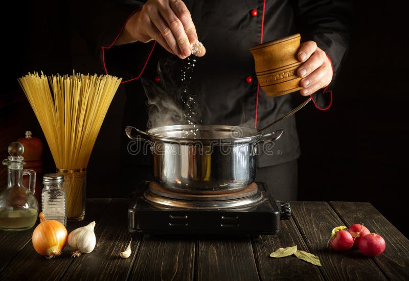 The Chef Cooks Italian Spaghetti in a Pan in the Kitchen. Grande ...