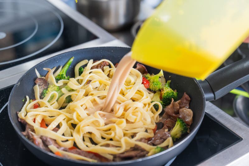 The Chef Cooks Pasta in a Frying Pan. Stock Photo - Image of tomatoes ...