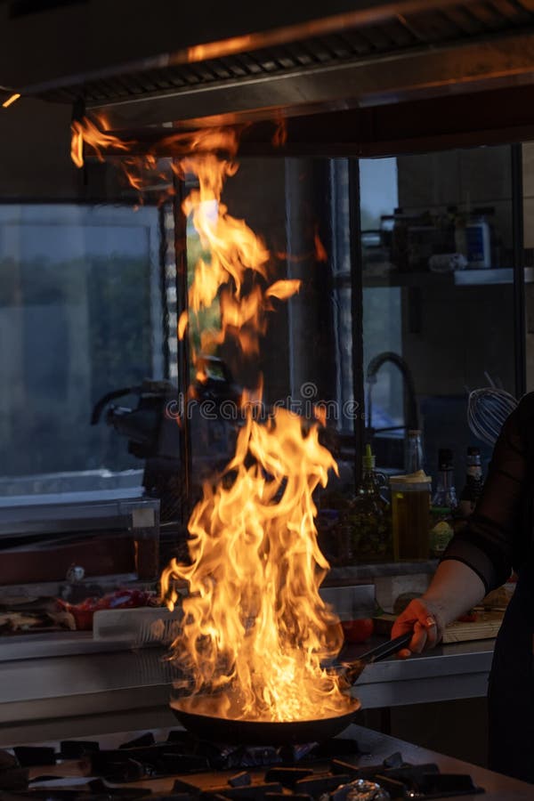 Chef Creates Flame in Pan. Chef Cooking with Flame in a Frying Pan on a ...