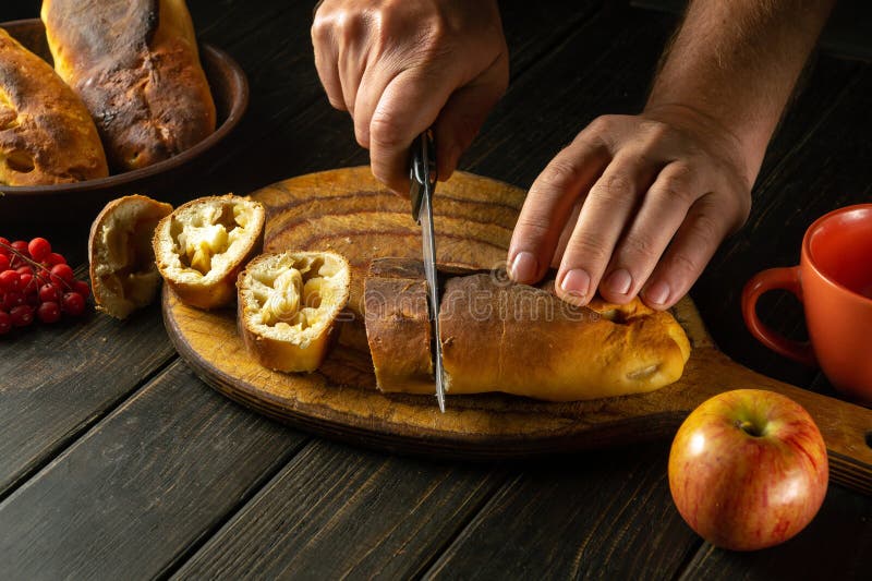 The Chef Cuts an Apple Pie Freshly Baked in a Bakery on a Kitchen ...