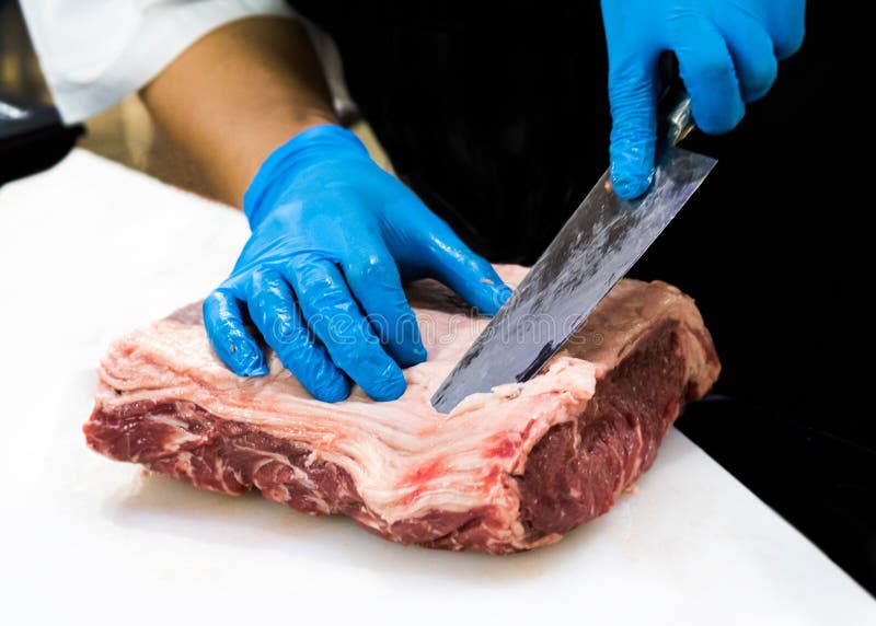 Chef Cuts Raw Meat with a Knife on a Board, Cook Cuts Raw Meat Stock ...