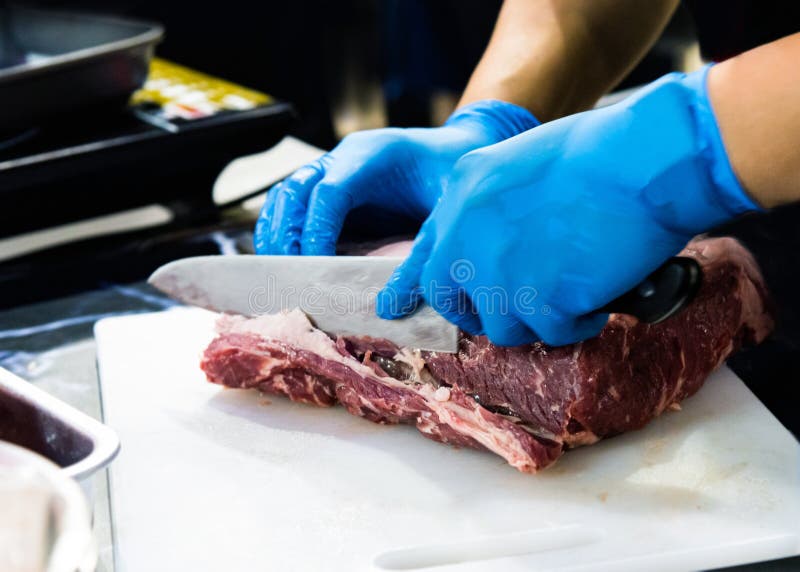 Chef Cuts Raw Meat with a Knife on a Board, Cook Cuts Raw Meat Stock ...