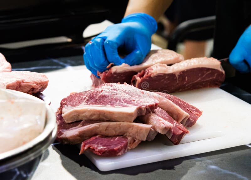 Chef Cuts Raw Meat with a Knife on a Board, Cook Cuts Raw Meat Stock ...