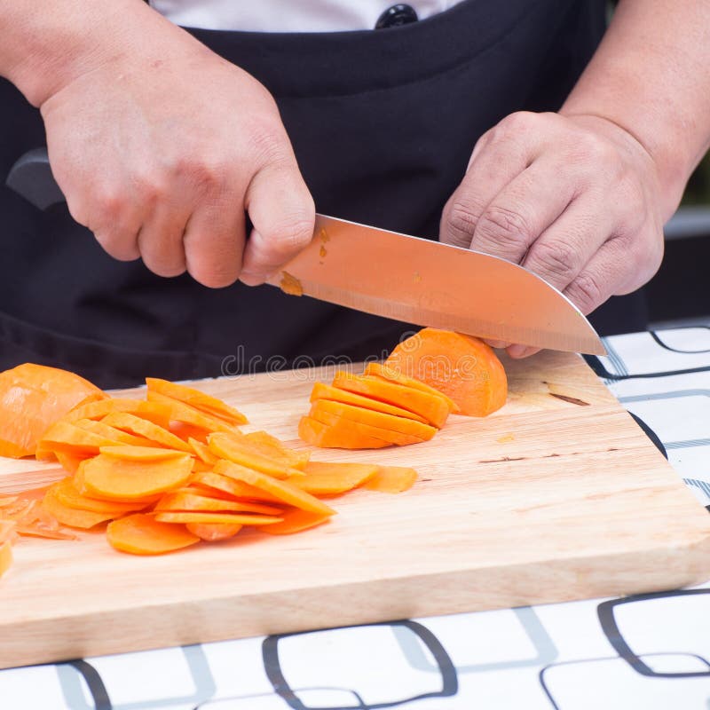 Chef is cutting carrots stock photo. Image of organic - 77549006