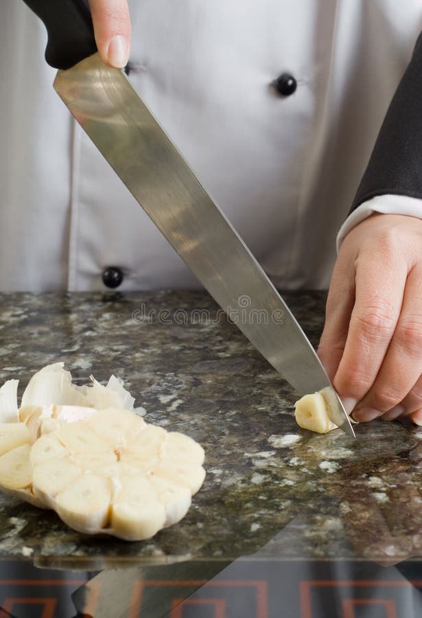 Chef Cutting Clove of Garlic Stock Photo - Image of reflection ...