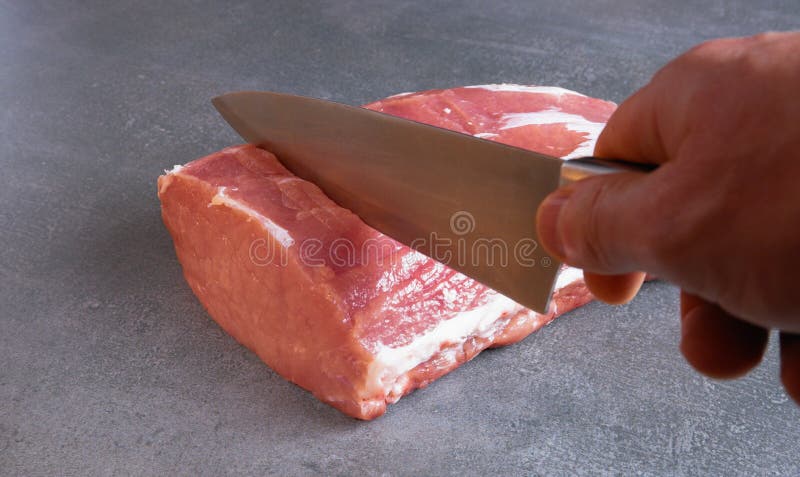The Chef is Cutting Fresh Raw Meat into Steaks. Close-up on a Gray ...