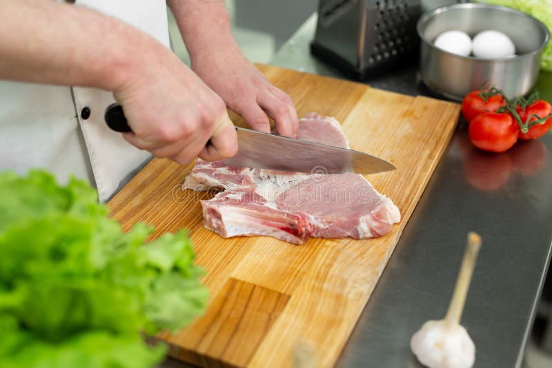 Chef Cutting the Meat on a Wooden Board. Stock Image - Image of knife ...