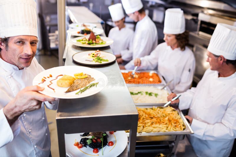 Chef Handing Food Dish To Waitress at Order Station Stock Photo - Image ...