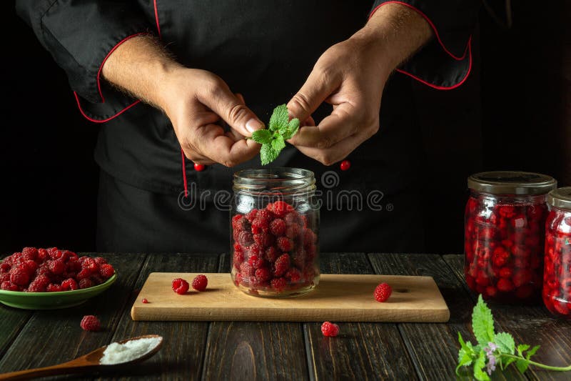 Chef Hands Adding Aromatic Green Mint To a Jar of Raspberries before ...