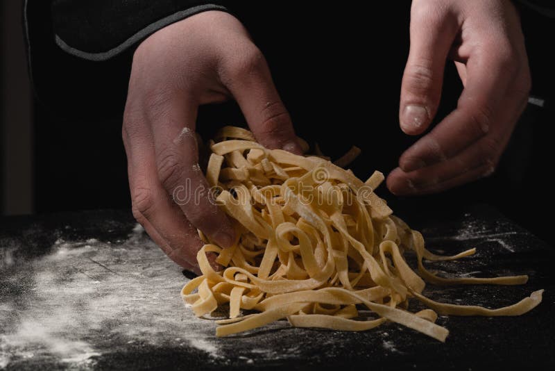 Chef Hands Making Spaghetti, Pasta, Noodles with Fresh Pasta on Black ...
