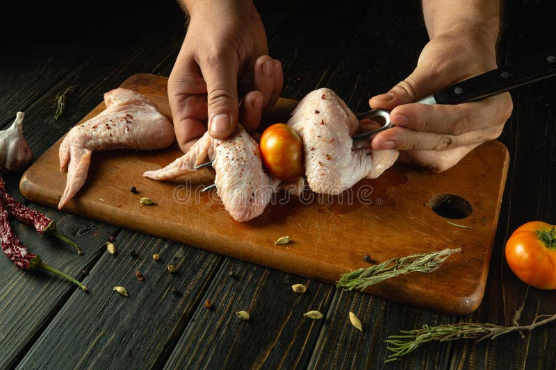Chef Hands Preparing Chicken Wings for Grill. the Cook Hands Skewering ...