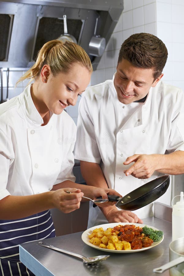 Chef Instructing Male Trainee in Restaurant Kitchen Stock Image - Image ...