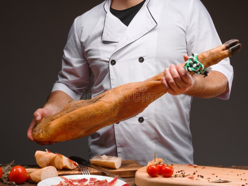 The Chef in the Kitchen with Ham in Hands. Traditional Jamon Stock ...