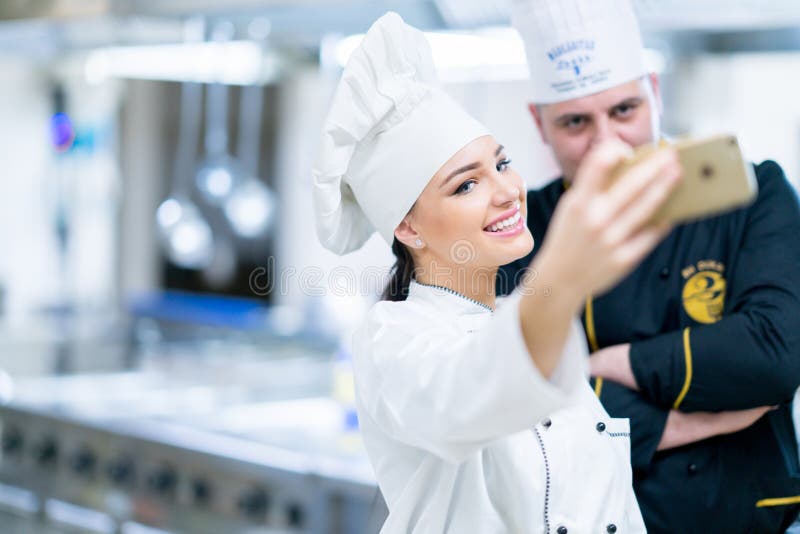 Chef in Kitchen and His Young Assistant Taking Selfie Stock Image ...