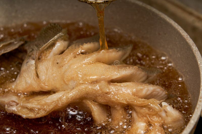 A Chef in the Kitchen is Making Fried Fish, Frying a Whole Fish Stock ...