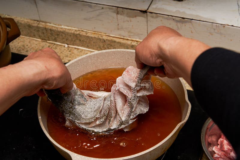 A Chef in the Kitchen is Making Fried Fish, Frying a Whole Fish Stock ...